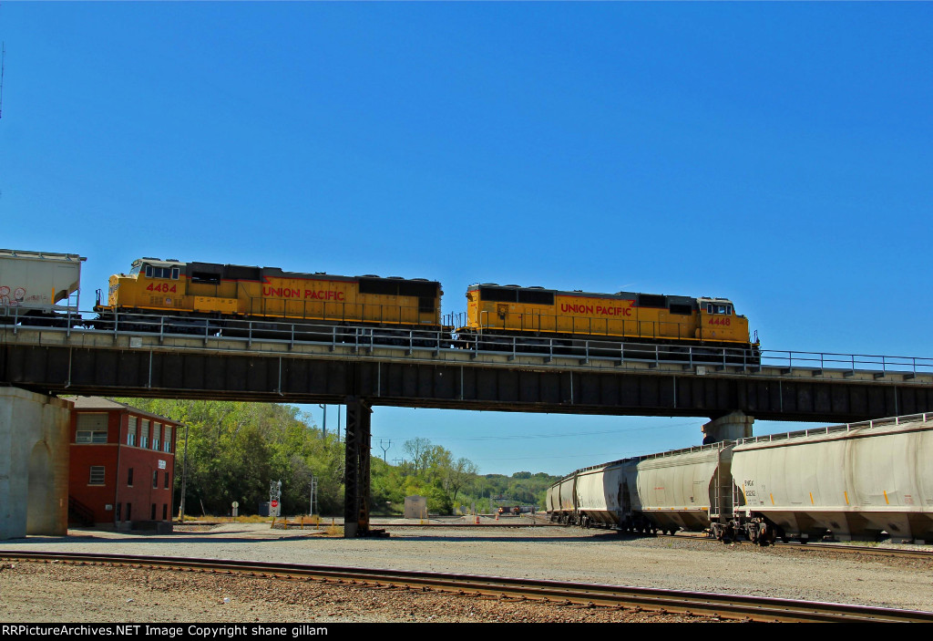 UP 4448 leads a Wb freight on the bridge with 3 bnsf trains below.